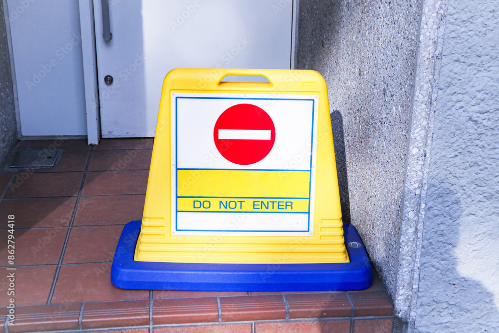 Do Not Enter or no entry sign made of yellow plastic stick on road ...