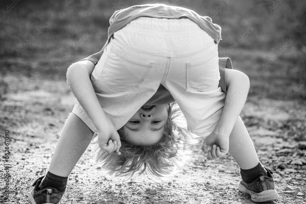 Boy standing looking through his own legs. Baby boy playing upside down ...