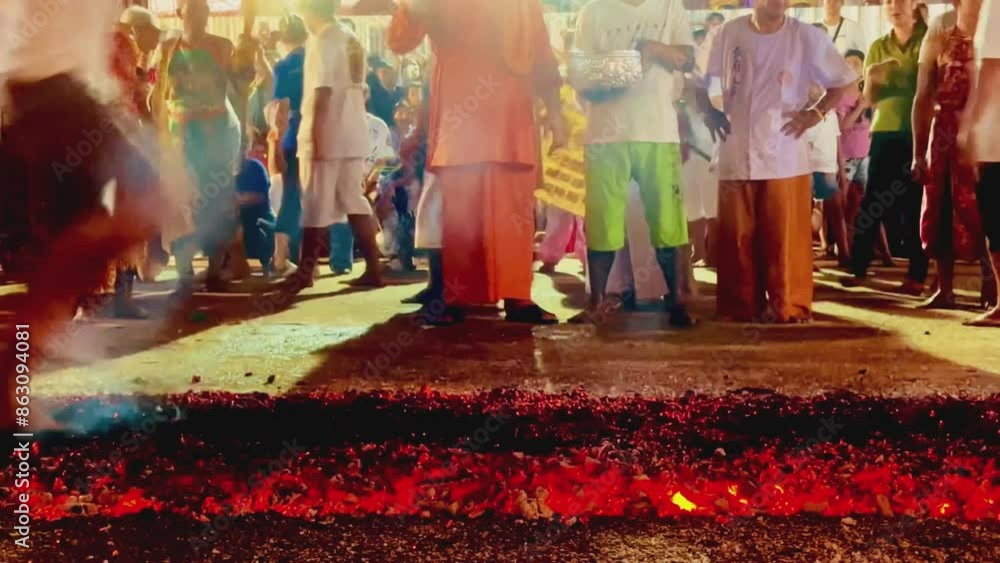 This image shows a man running over a burning bonfire during a fire ...