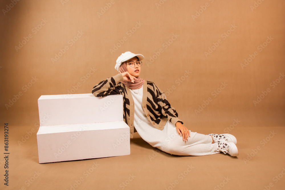 Posing from above Beauty of a young Asian woman in hijab and white hat ...