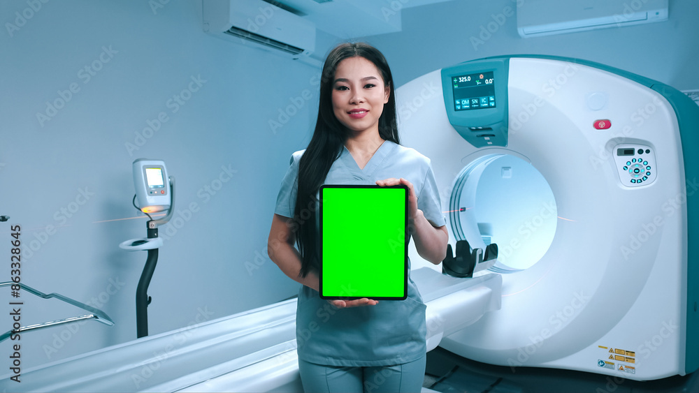 Young tomographer holding tablet with chroma key. Smiling doctor ...