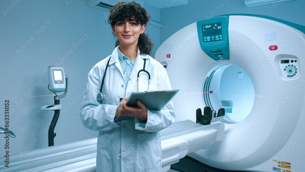 Young tomographer getting ready for procedure. Cheerful doctor smiling ...