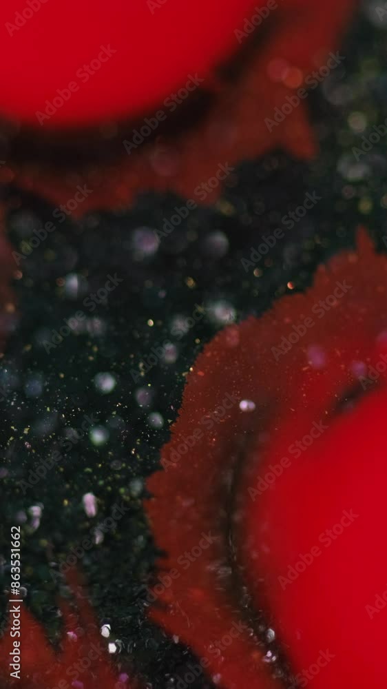 Vertical video. Ink drop. Paint splatter. Defocused red color wet stain ...