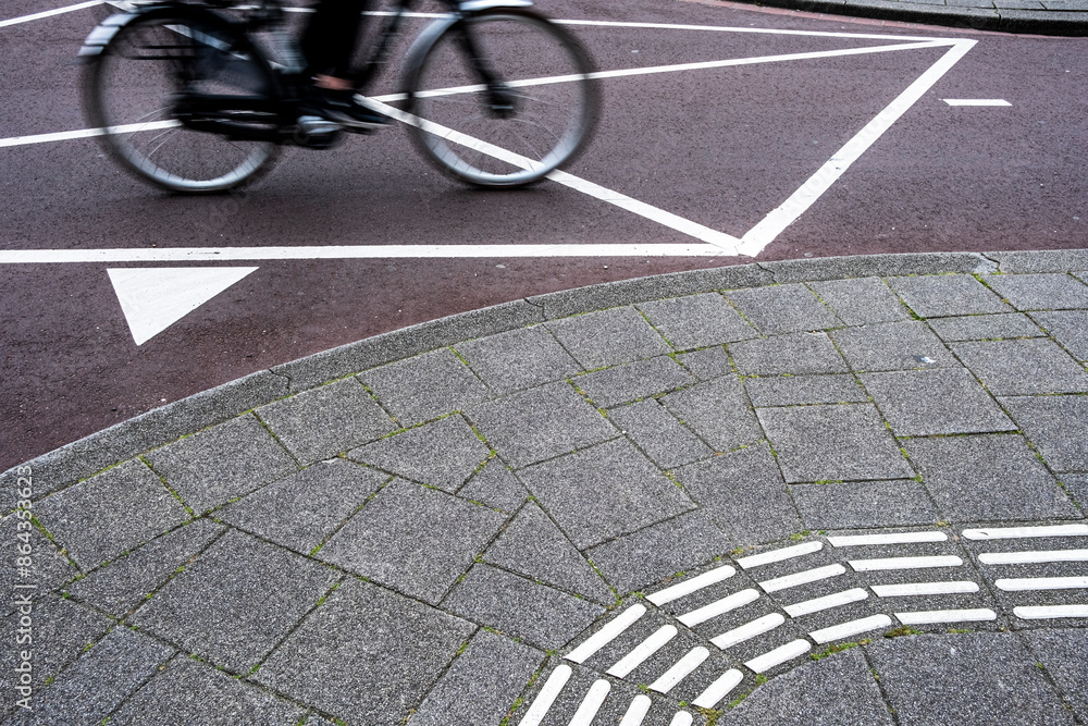 This image captures a cyclist in motion on a curved path with geometric ...