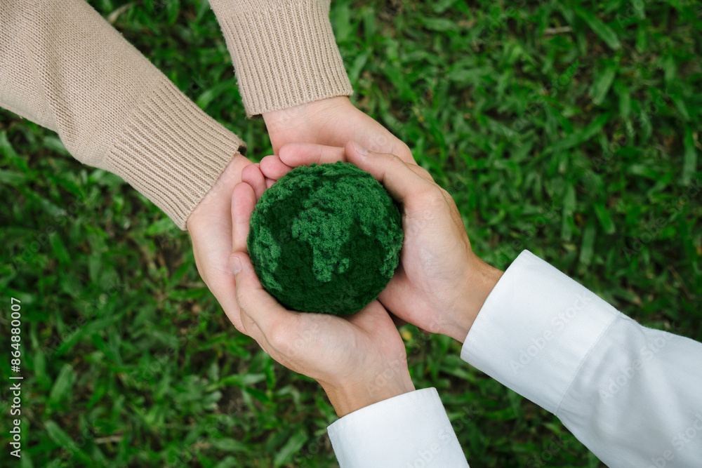 Two hands holding green earth together on nature background for the ...