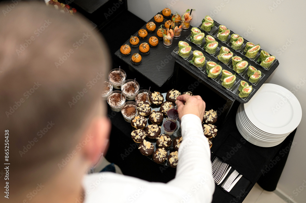 Buffet table with appetizers and desserts. man takes food from table ...