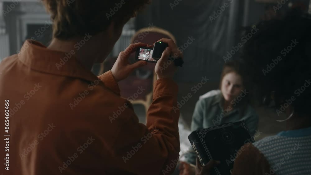 Back view of guy filming video on vhs camera of writhing demon ...