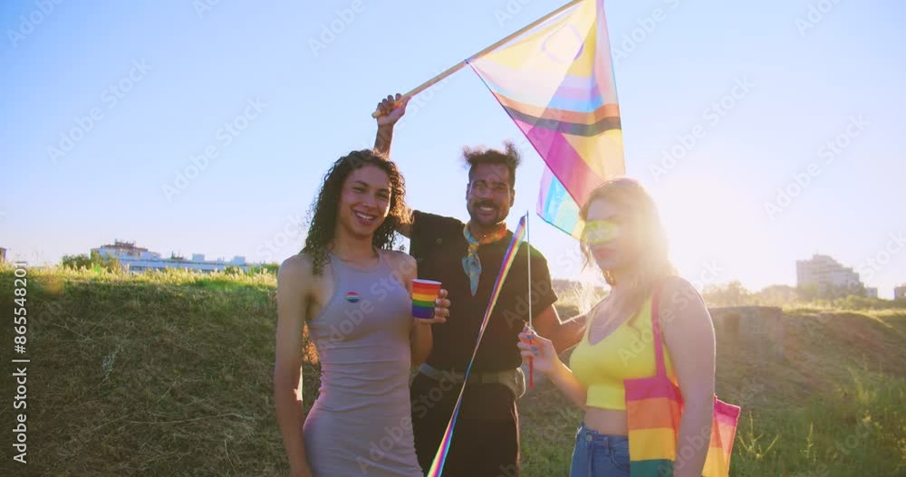 diverse and inclusive friends smile to camera and rise LGBT flag whit ...
