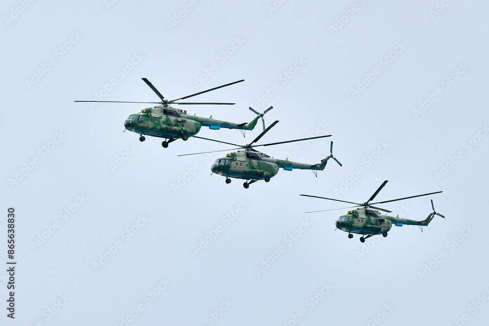 Three Russian military helicopters armed with missiles flies in blue ...