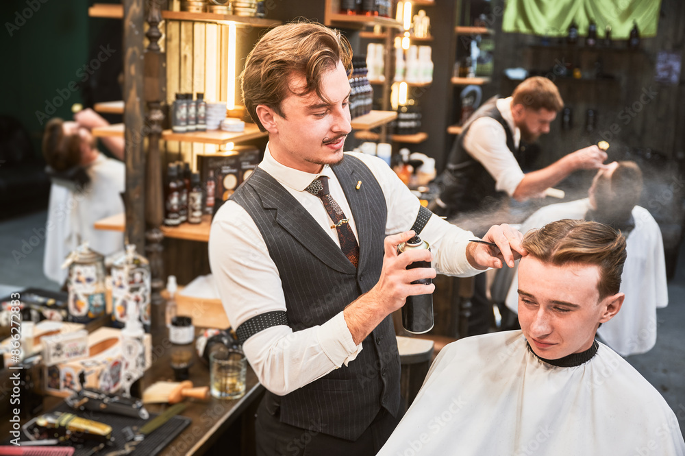 Professional barber using hairspray to finish hairstyle. Stylish ...