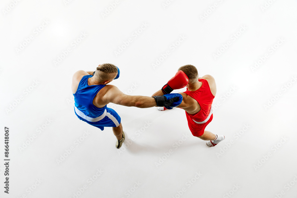 Overhead view of two boxers in action, one in red gear throwing punch ...