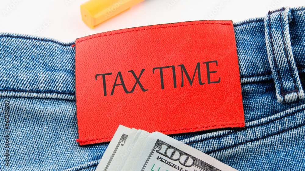 Business and tax concept. TAX TIME on the red leather label of jeans on ...