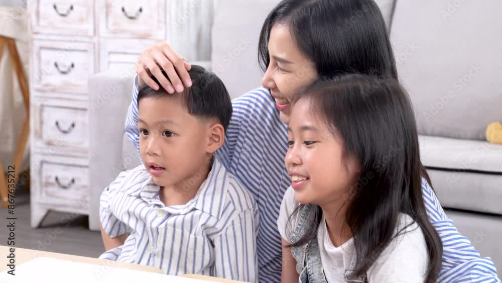 Cheerful Asian mother spend time with two sibling kids teaching ...