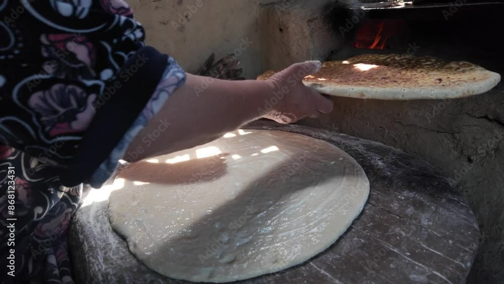 preparing bread in a traditional Dagestan village bakery. Bread is a ...