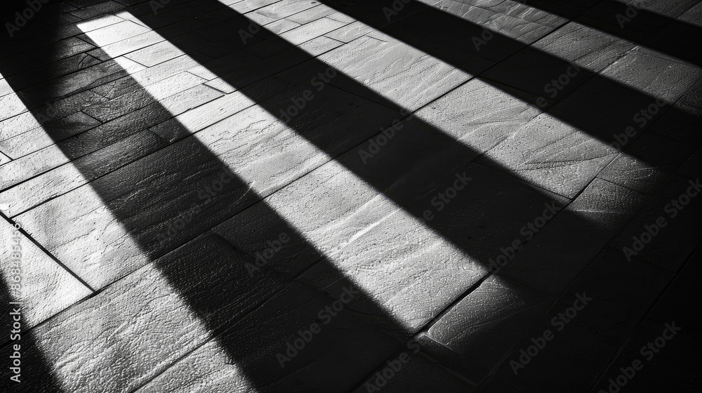 Long shadows cast by vertical objects stretch across a textured brick ...
