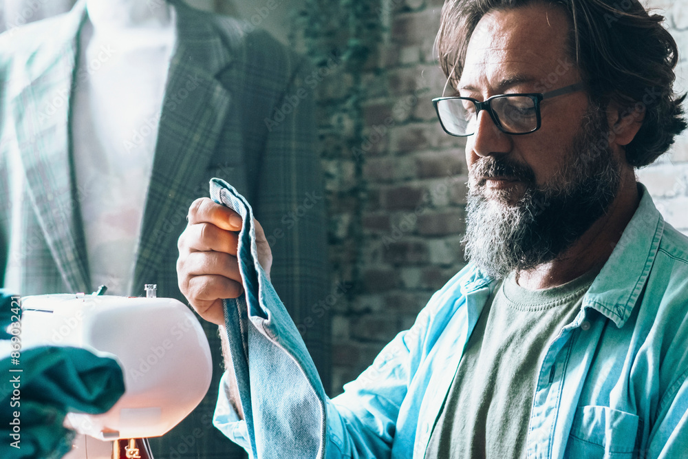 Professional tailor man working with sewing machine alone in the ...