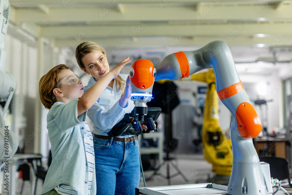 Mom and boy during take your kid to work day, encouraging children in career in robotics. Field ...