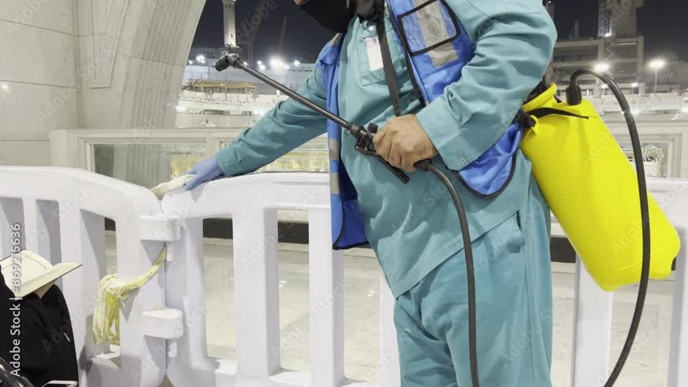 Mecca, Saudi Arabia - 18 FEB 2022 circa: Cleaner disinfecting the fence ...
