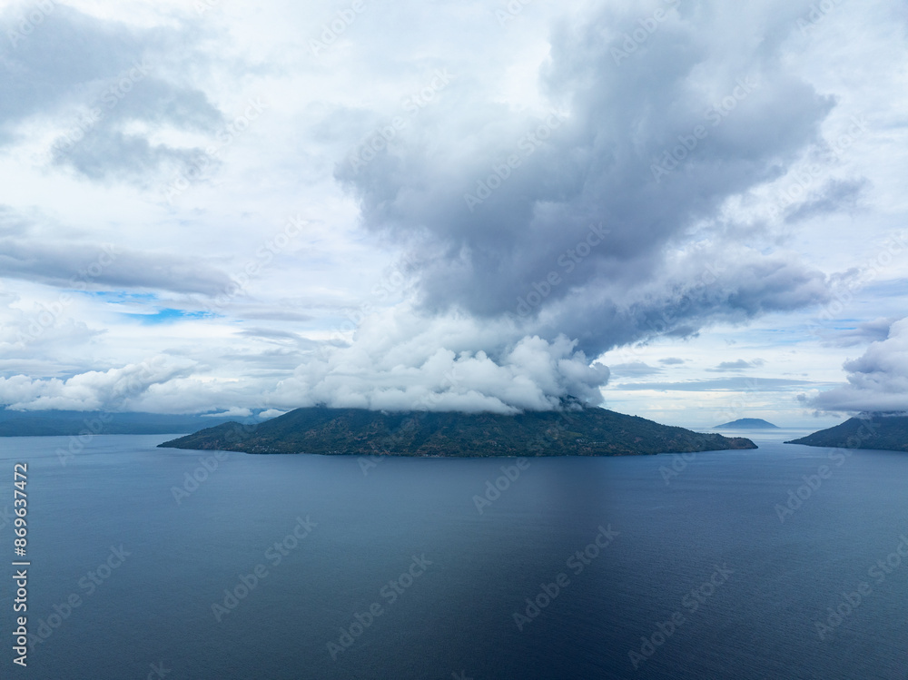 Clouds gather over the volcanic island of Pulau Pura in the middle of ...