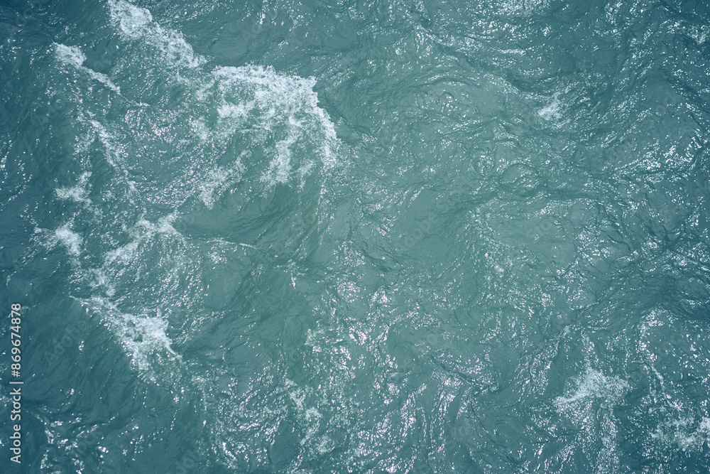 Waves and ripples in the sea close-up. The water is blue in color with ...