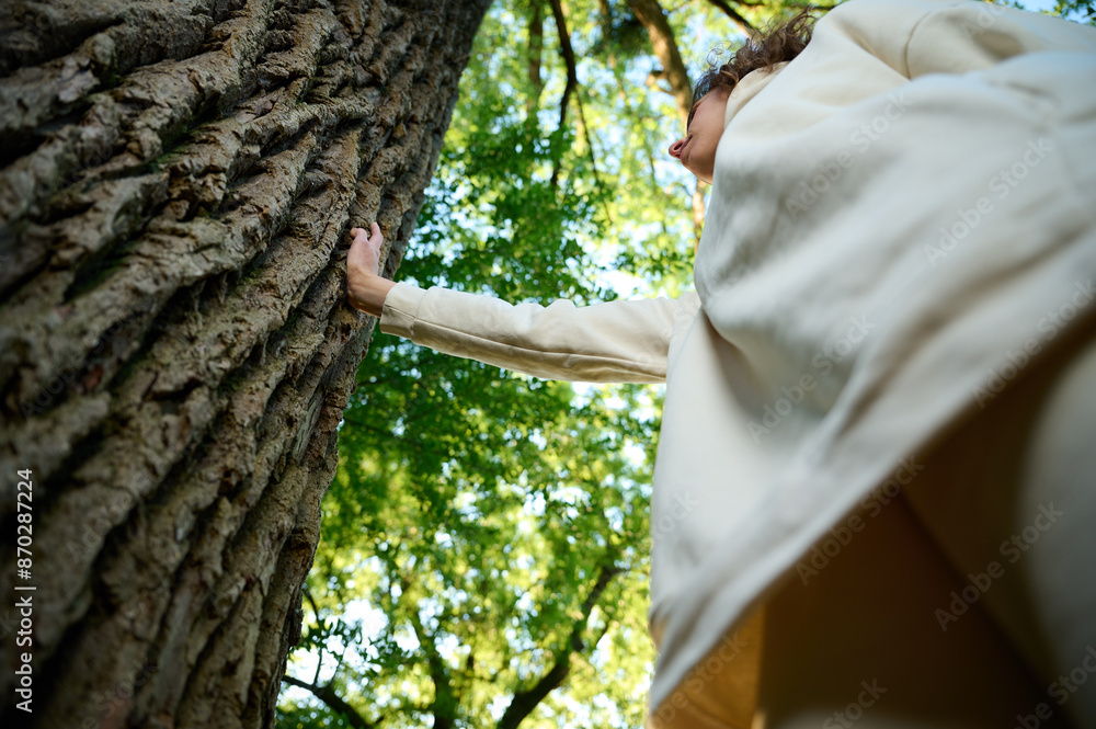 Pretty woman leaning on the old tree. Female hugging huge tree trunk ...
