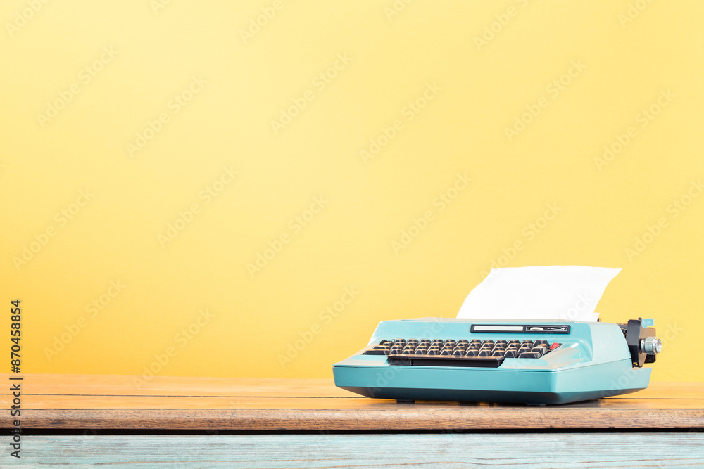 Retro typewriter from circa 1980s with sheet of paper on wooden desk ...
