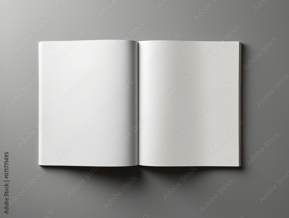 Blank open magazine mockup. The magazine is laid flat on a smooth, grey ...