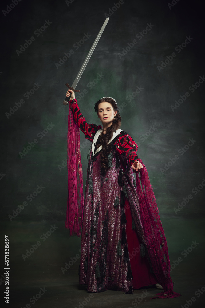 Woman in richly detailed Renaissance-style gown, holding sword aloft ...
