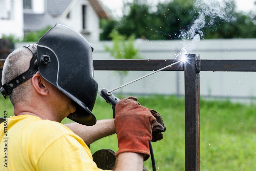 Foto de Welding Metal Fence Construction Outdoor. Welder in Mask and ...
