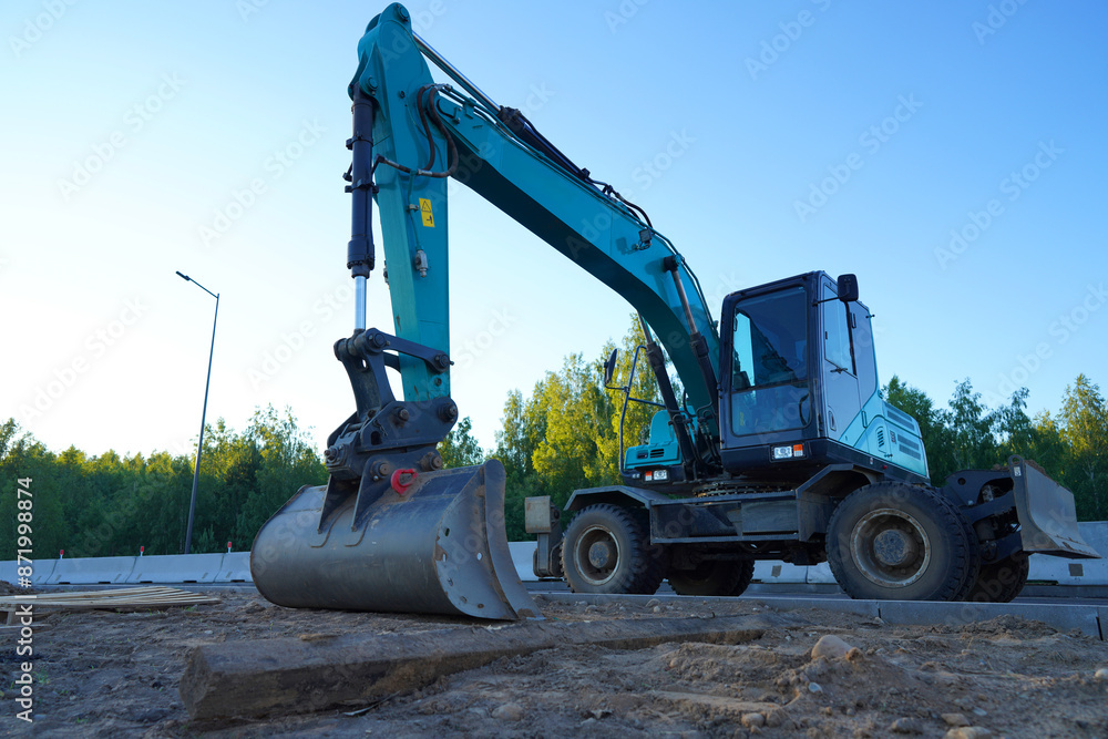 Excavator on road construction. Screeding ground for installing borders ...