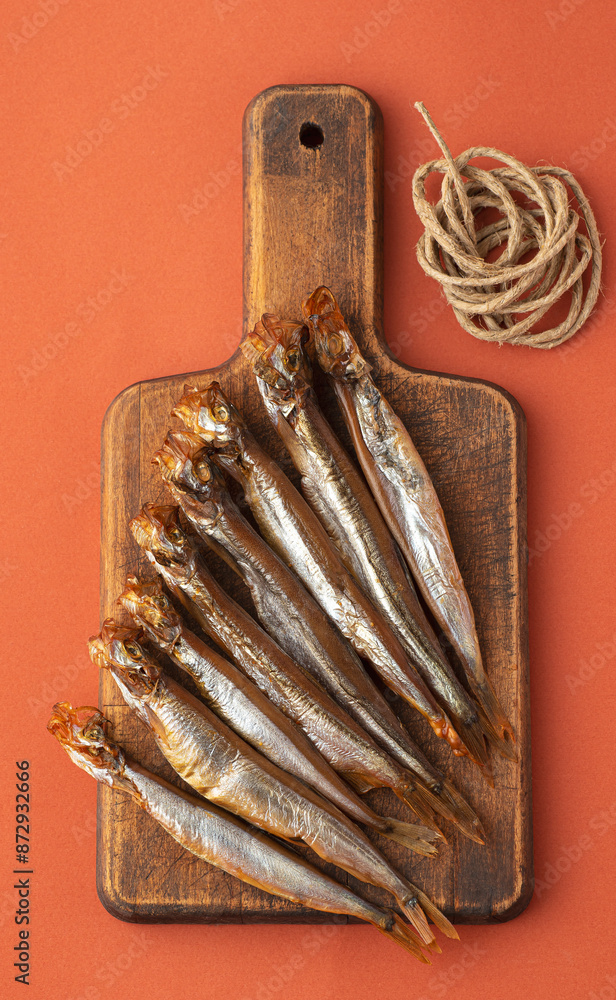 Smelt fish on the red background. Dry and smoked fish is a traditional ...