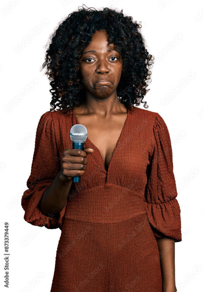 African woman with curly hair singing song using microphone depressed ...