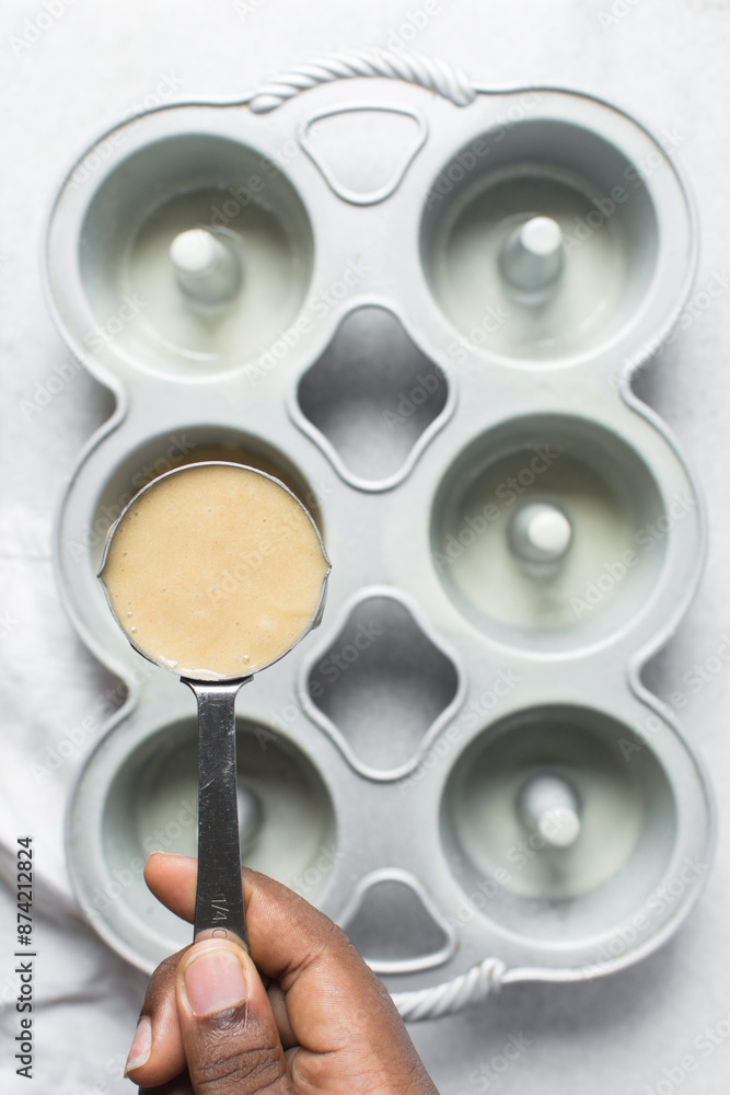 Putting cake batter in a mini bundt pan, Overhead view of vanilla cake ...