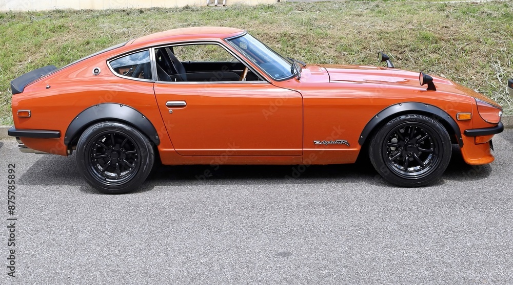 Azzida, Italy. July, 6 2024. Orange Datsun Fairlady Z, also known as Nissan Z during a classic ...
