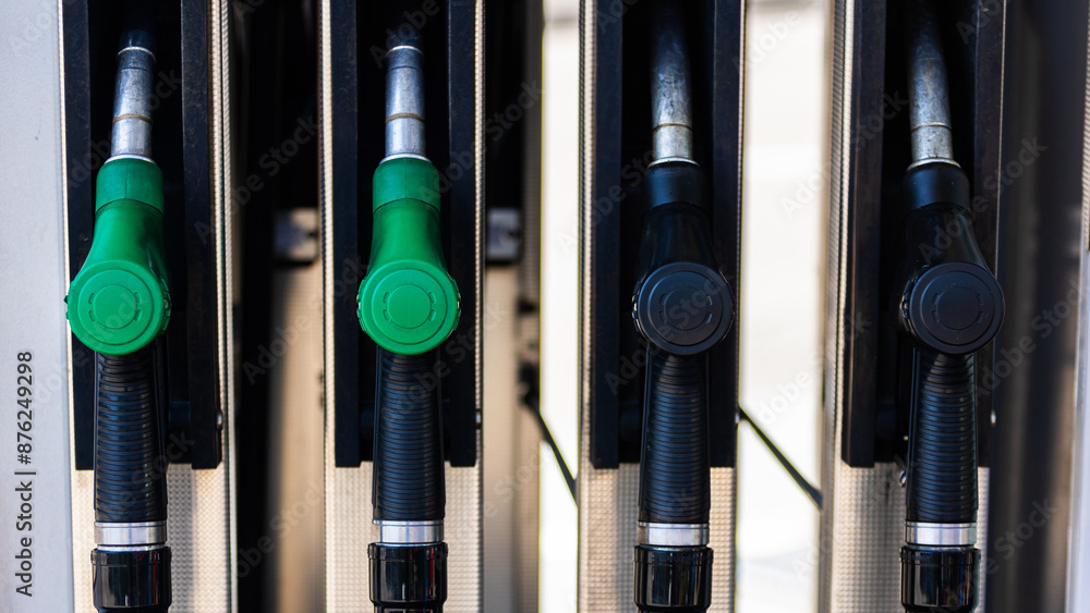 Fuel pump nozzles at a gas station, featuring both green and black ...