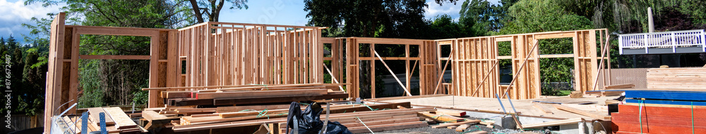 Wood framing started on new home construction, stacks of delivered ...