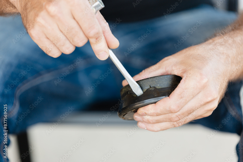 Man threading line into trimmer head of grass trimmer - step by step ...