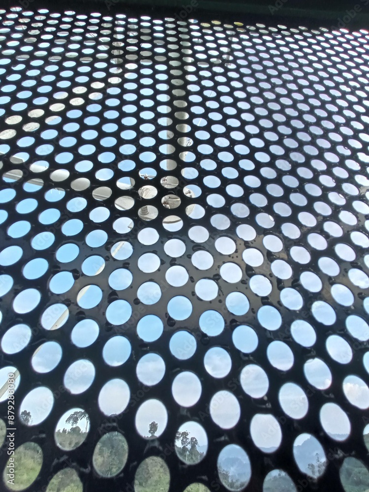 Iron windows with round perforated motifs with views of natural scenery ...
