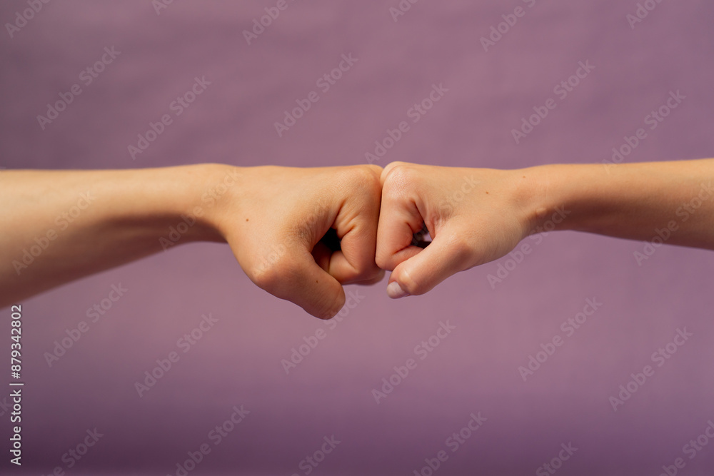 Beautiful female hand on isolated on purple background two hands fist ...