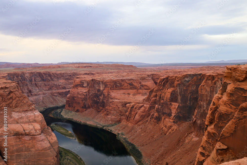 Towering red rock cliffs overlook the meandering Colorado River as it ...
