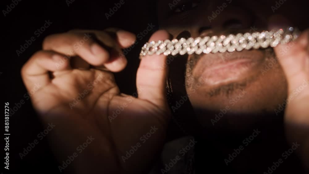 Closeup of narrow beam of light illuminating Black male rapper face on ...