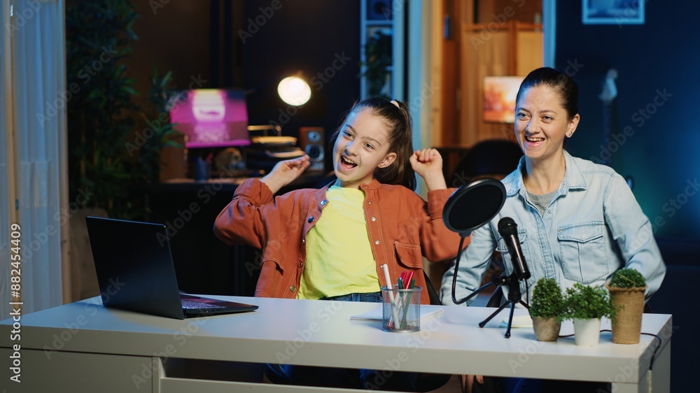 Young girl and her mother using recording devices to shoot intro for ...