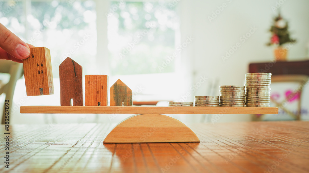Wood house and Coins stack with balance scale. Money management ...