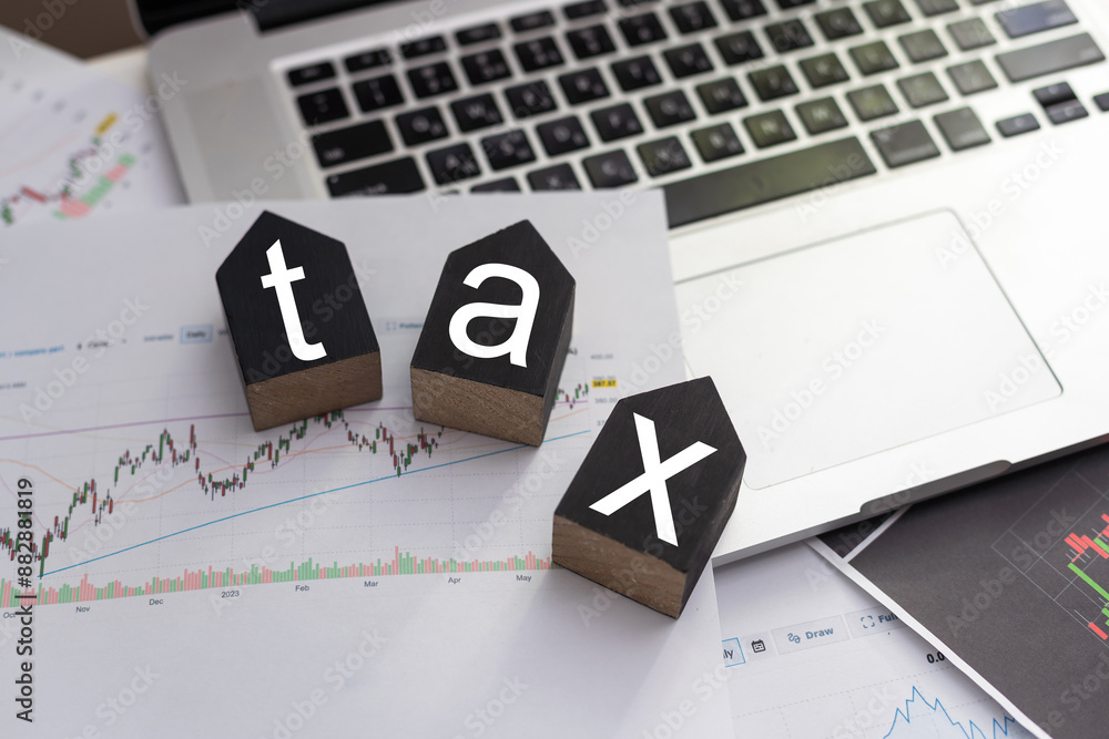 Tax text in wooden cubes and tax or vat form documents to complete ...