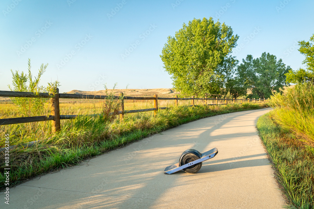 One-wheeled electric skateboard in the late summer morning on the ...