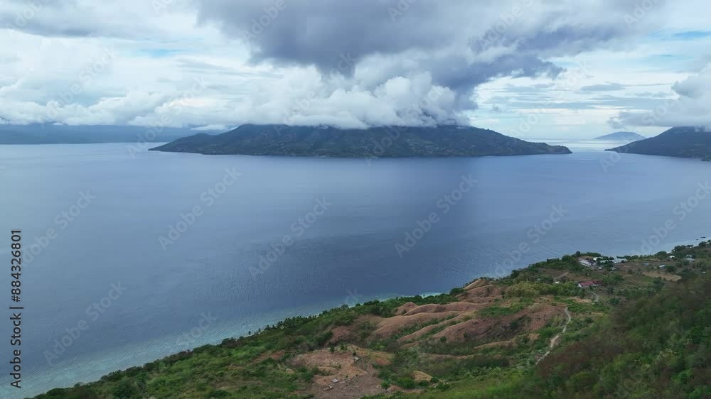 Clouds gather over the volcanic island of Pulau Pura in the middle of ...