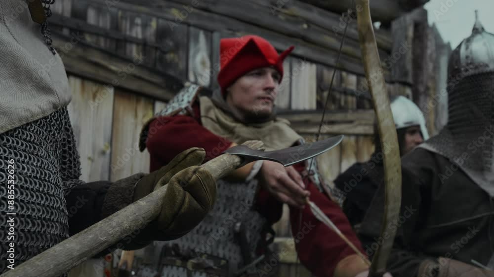 Medium shot of young Caucasian male archer in red uniform and armoured ...