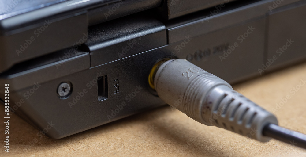 Simple generic power adapter cord plug plugged into a laptop computer ...