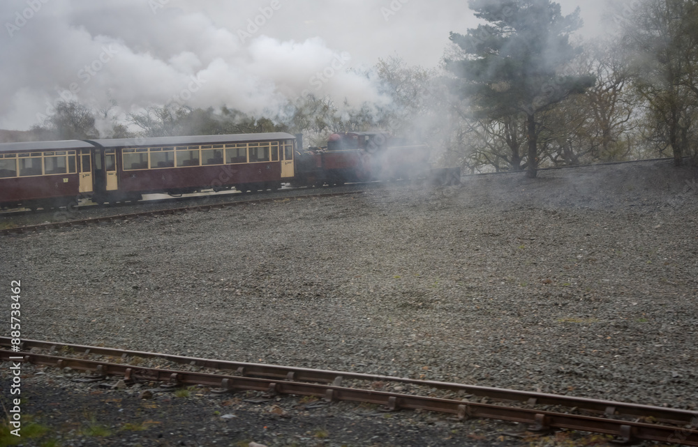 a vintage steam train and passenger carriages taking a bend in the ...