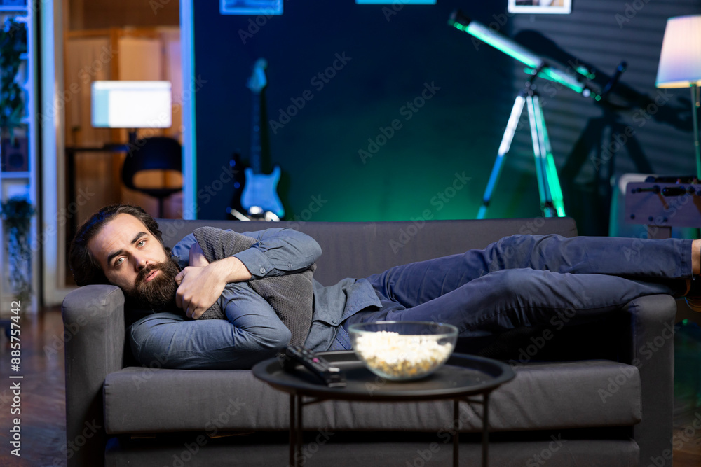 Man in apartment watching horror movie broadcasted on TV, hugging ...